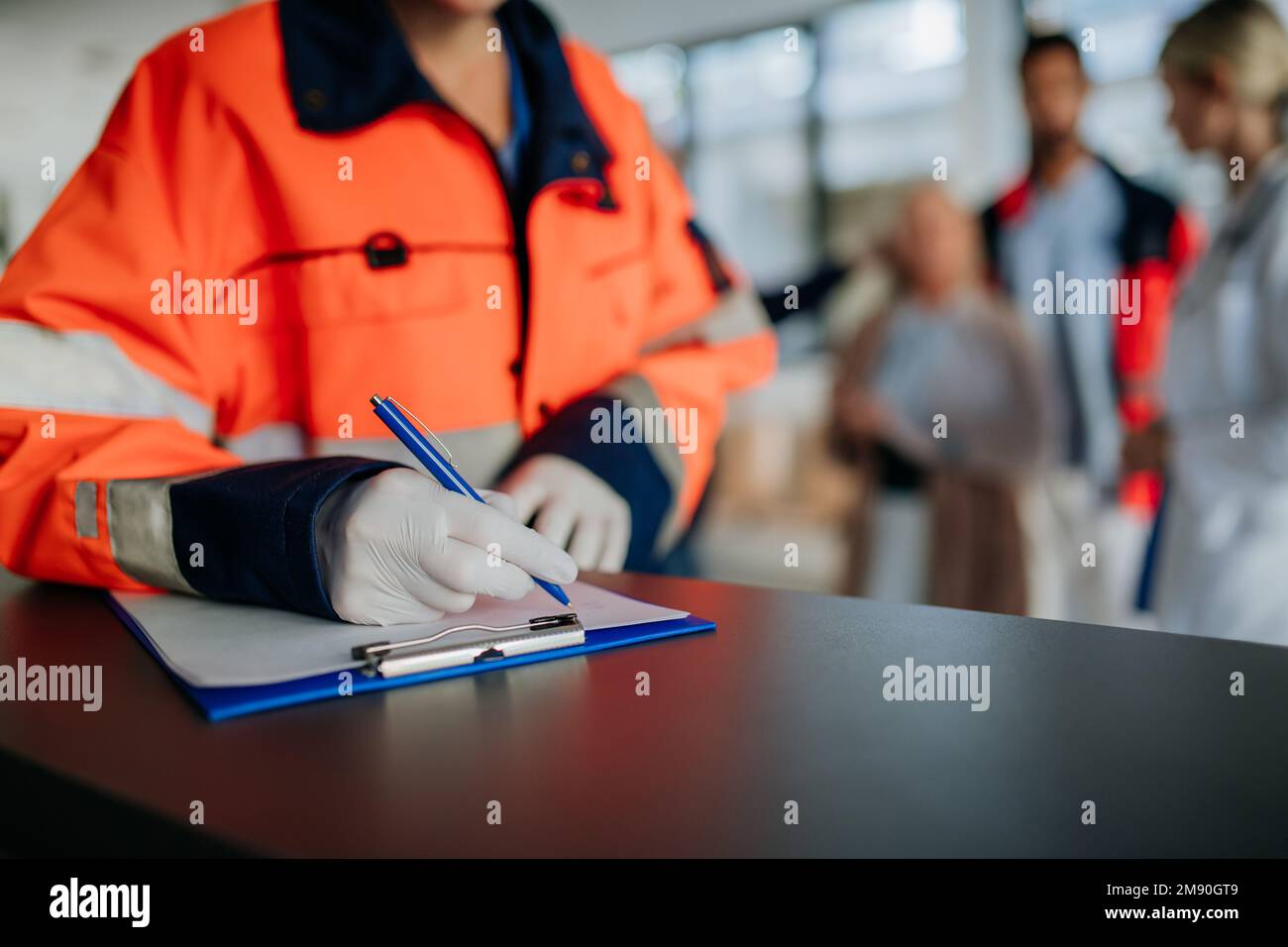 Close-up of rescuer filling out papers at hospital corridor Stock Photo ...