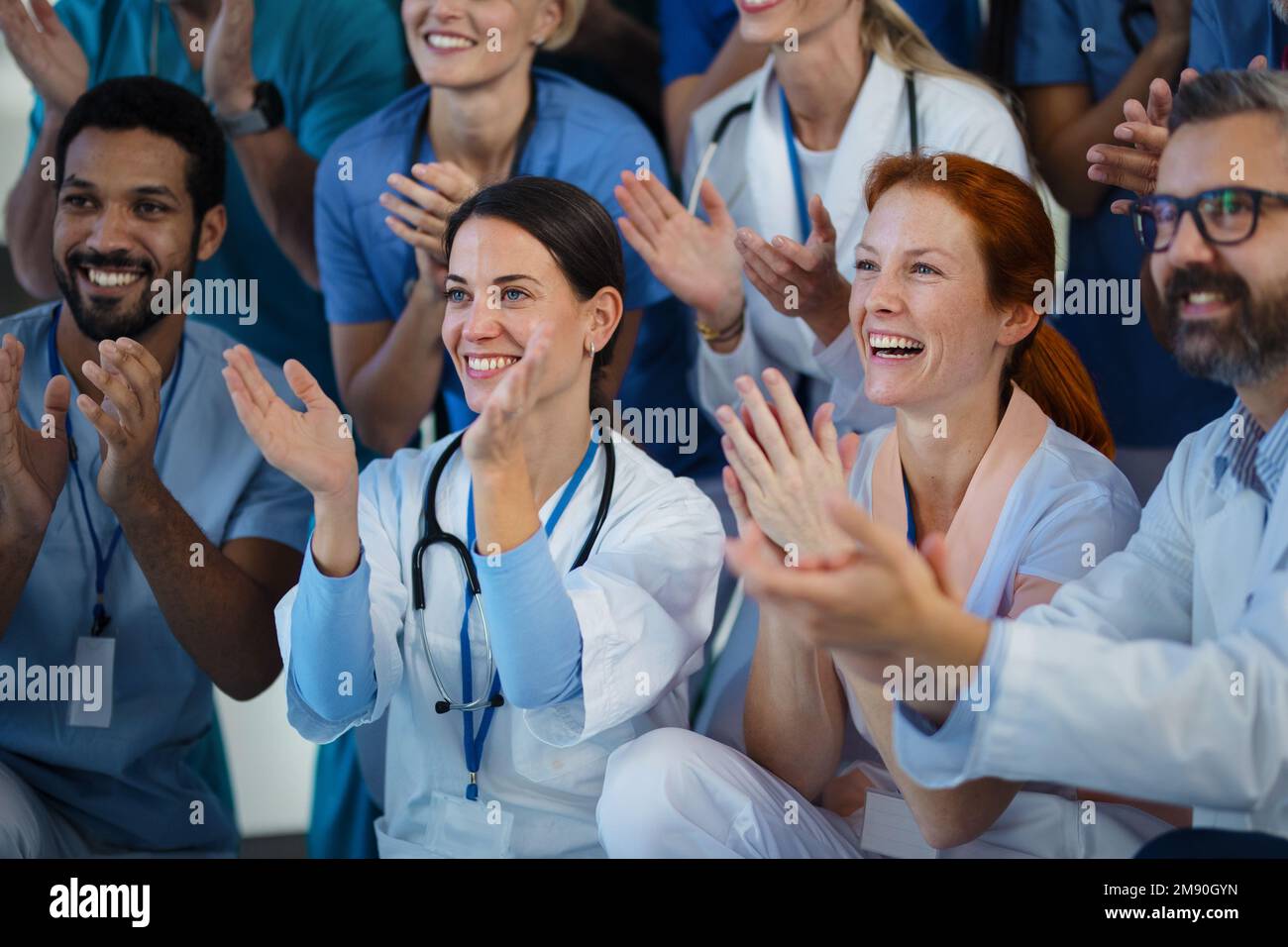 Portrait of happy doctors, nurses and other medical staff clapping in ...