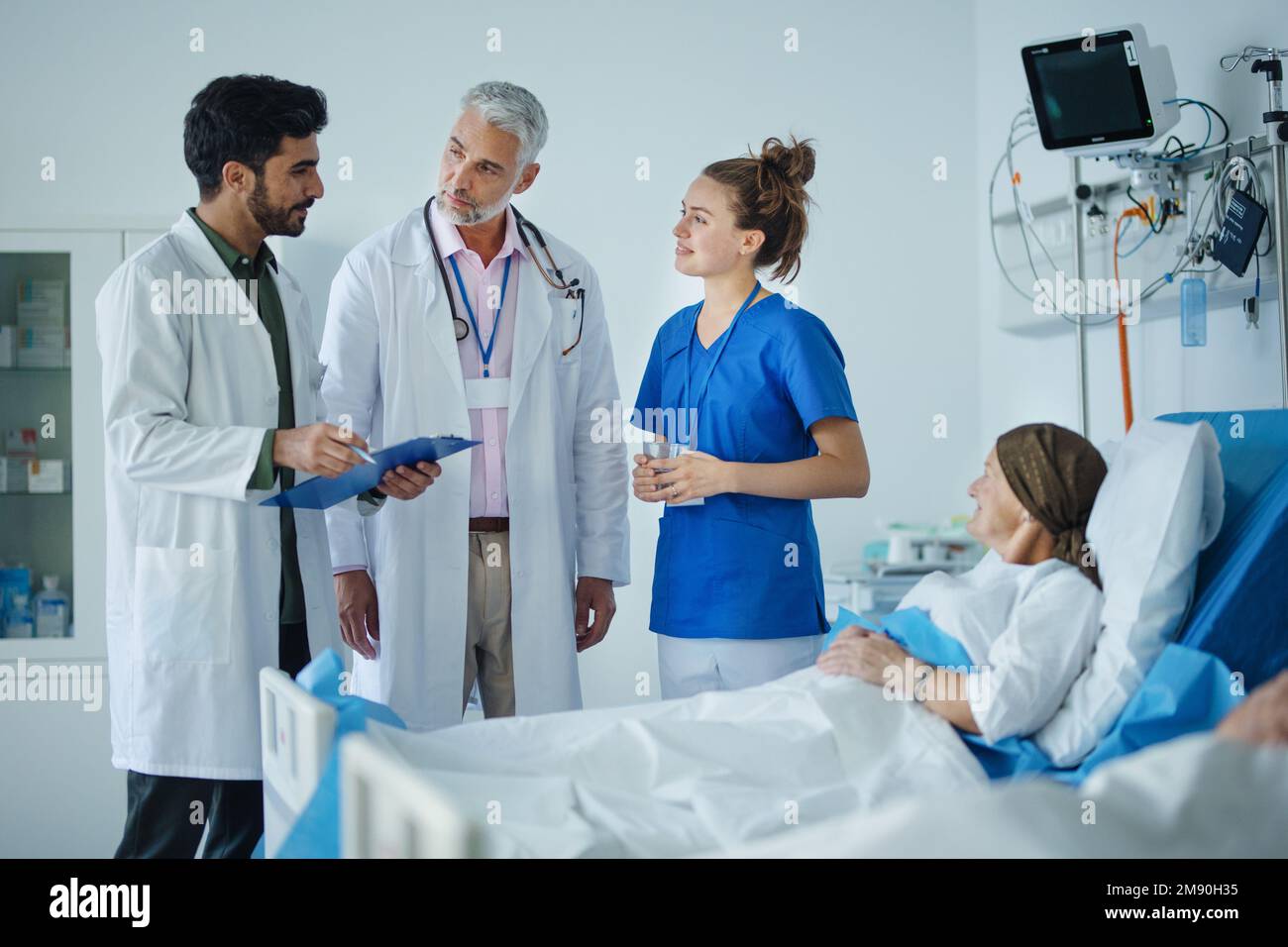 Senior woman lying in hospital room after chemotherapy, medical stuff ...