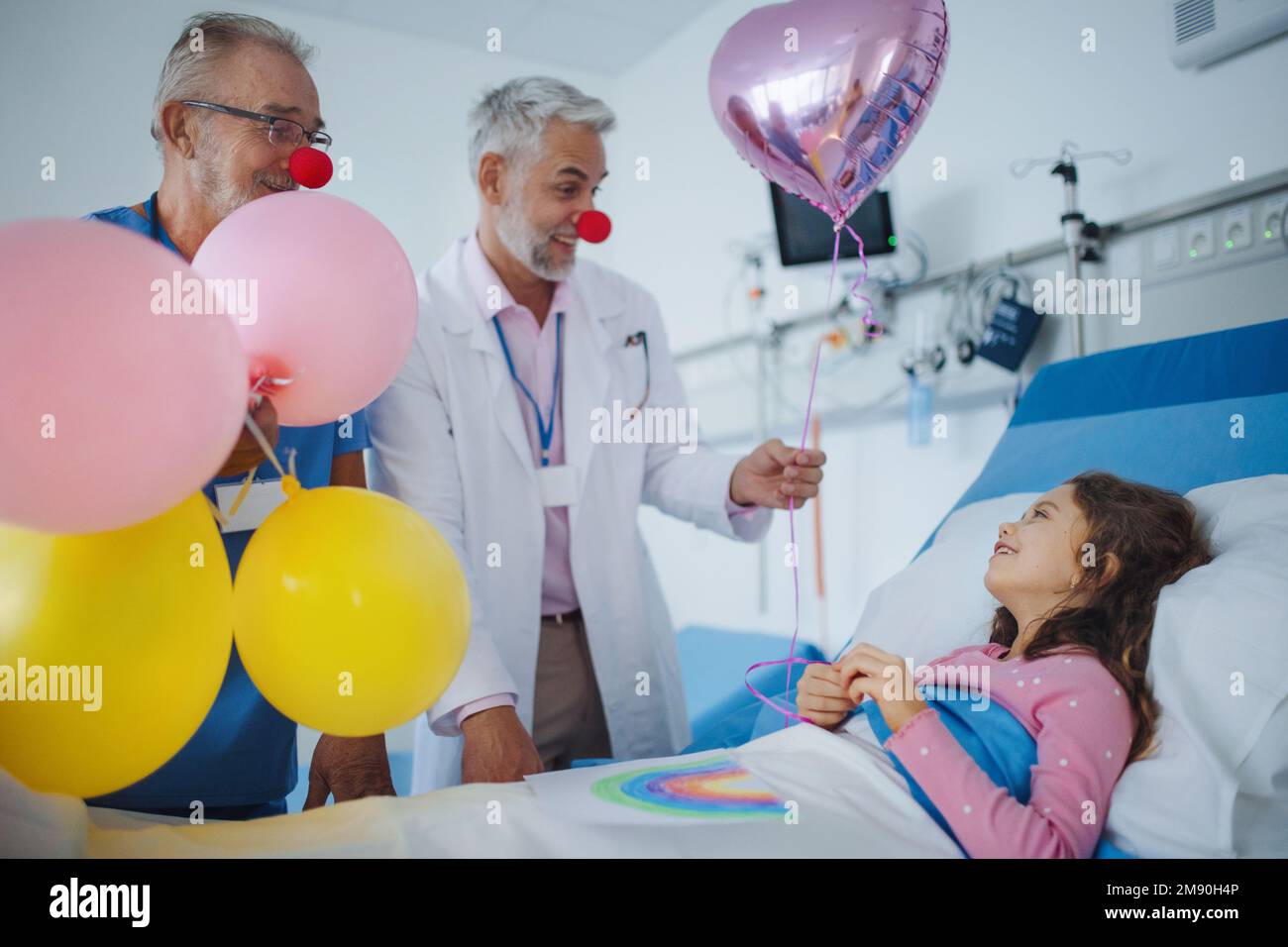 Happy doctors with clown red noses celebrating birthday with little ...