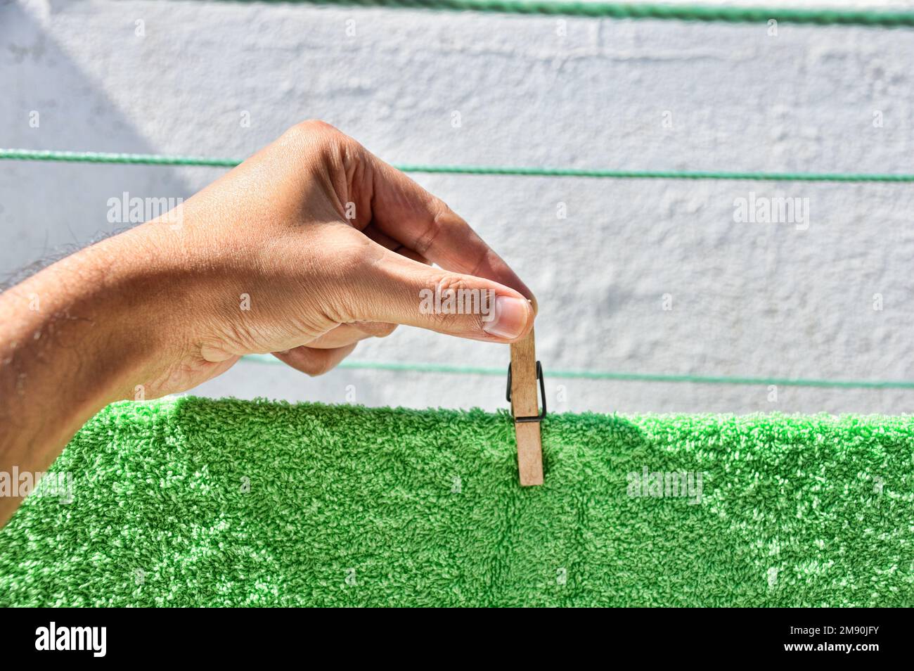 Man hand hanging up laundry at terrace Stock Photo - Alamy