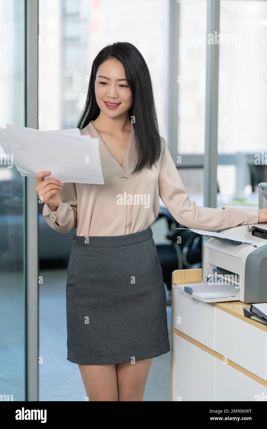 Young business lady use printer Stock Photo - Alamy