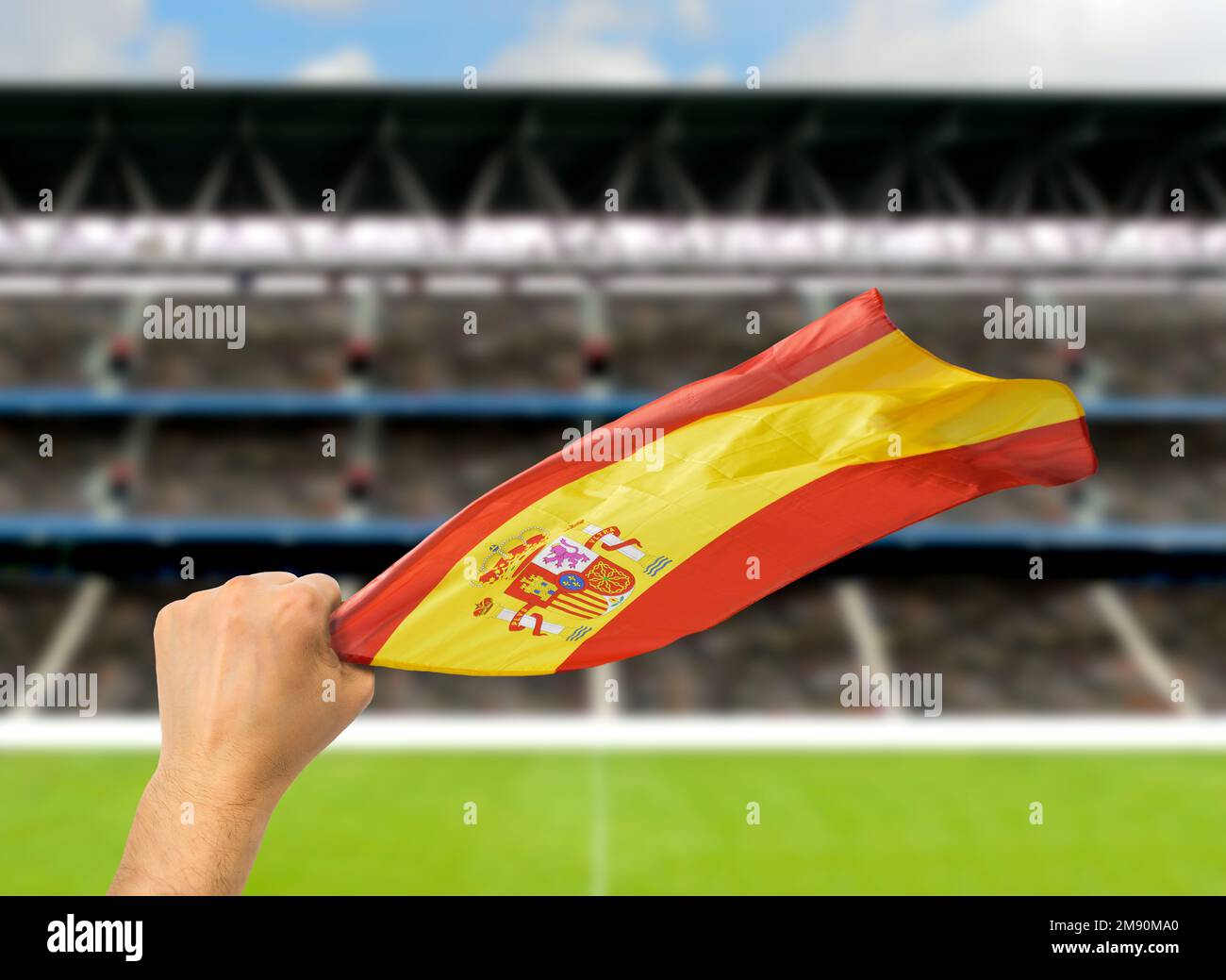 Spanish fan holding the flag of Spain at stadium.International soccer ...