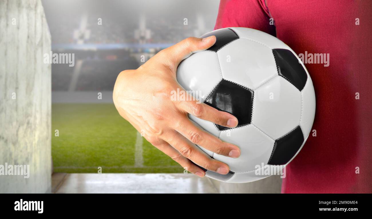 Cropped image of a young man holding a soccer ball with his hand ...