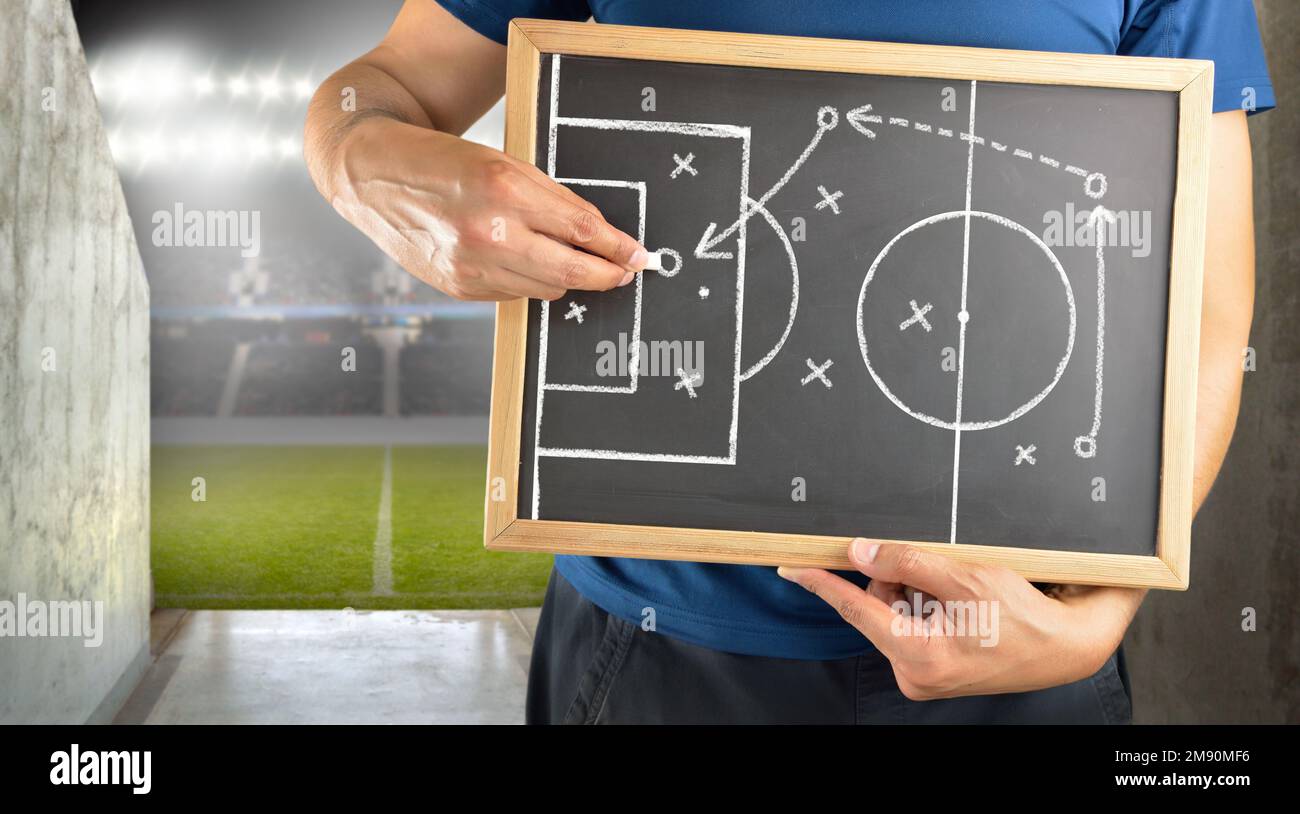 hand of a football coach drawing a tactics of soccer game with white ...