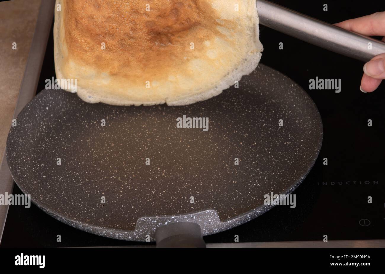 photo of a fried pancake being flipped over a hot pan Stock Photo - Alamy