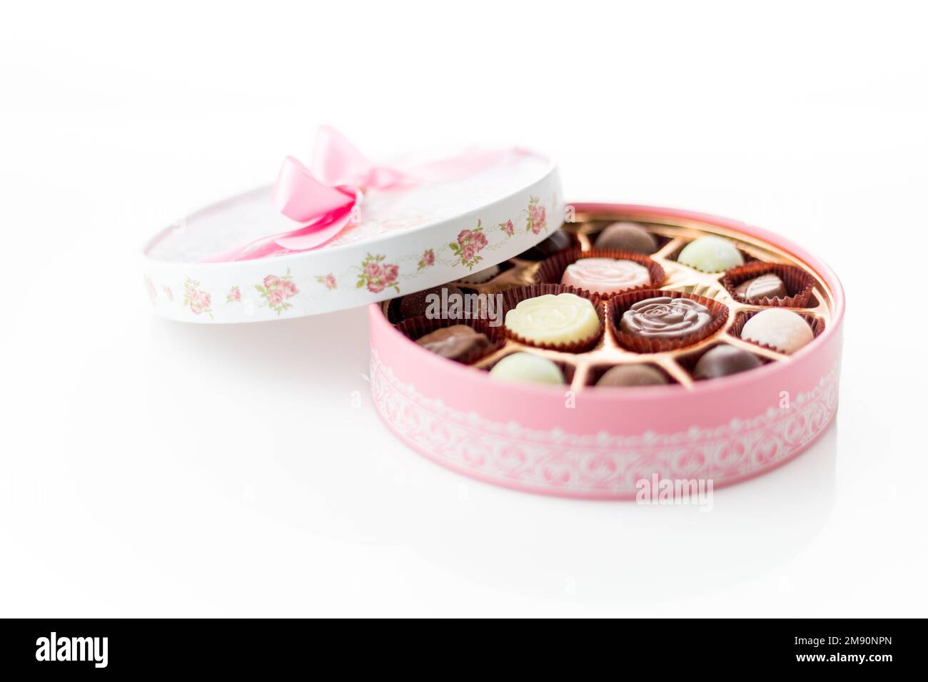 Pink box of chocolates with ribbon on white background Stock Photo - Alamy