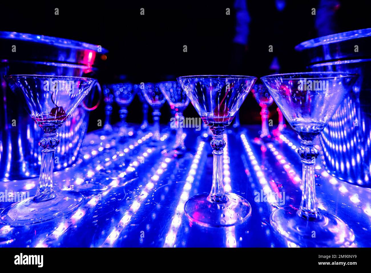 empty glasses of alcoholic cocktails on the colorful bartender show in ...