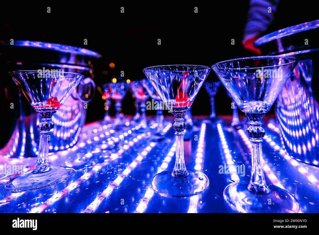 glasses of alcoholic cocktails on the colorful bartender show in the ...