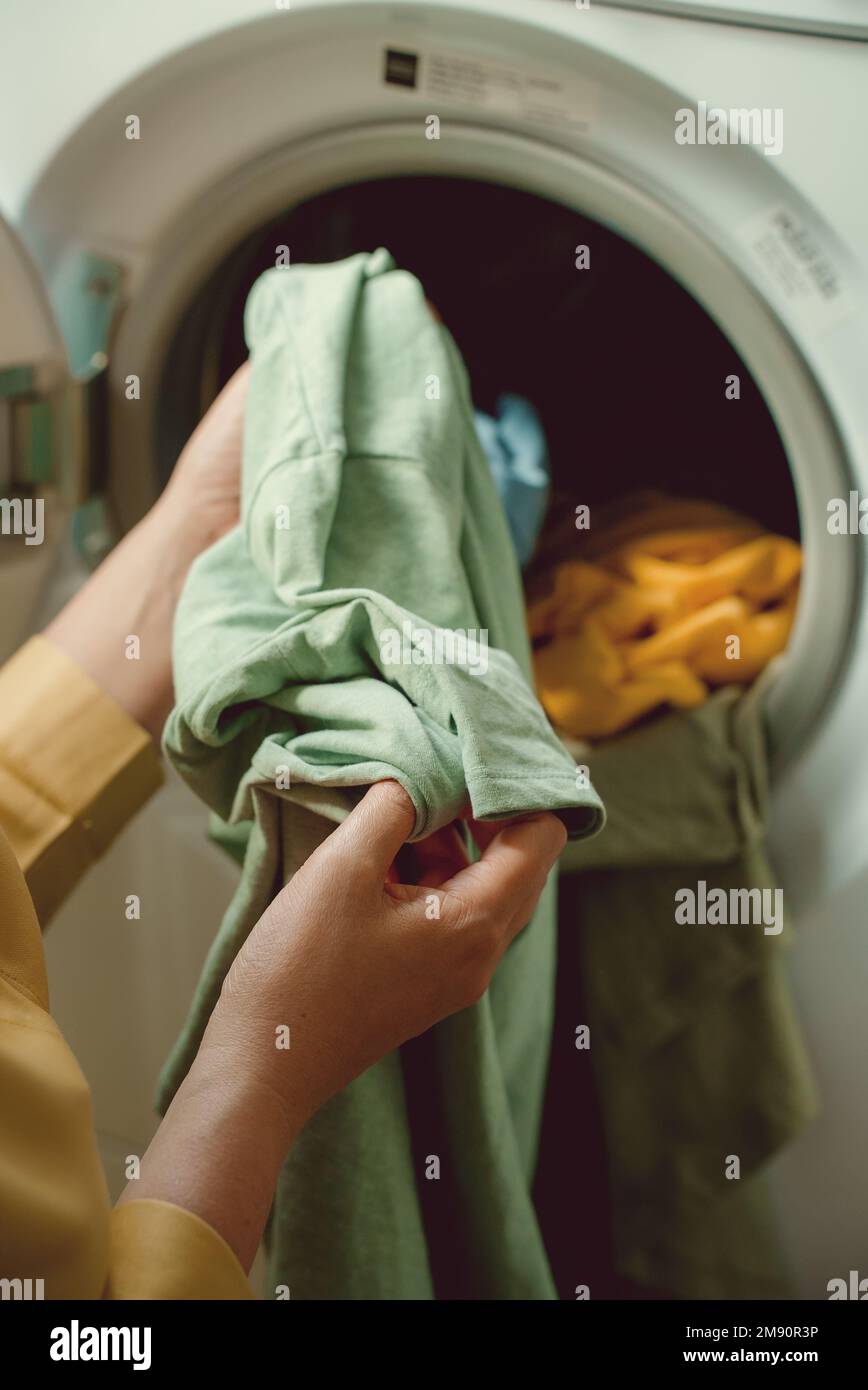Woman loading clothes into washing machine Stock Photo - Alamy