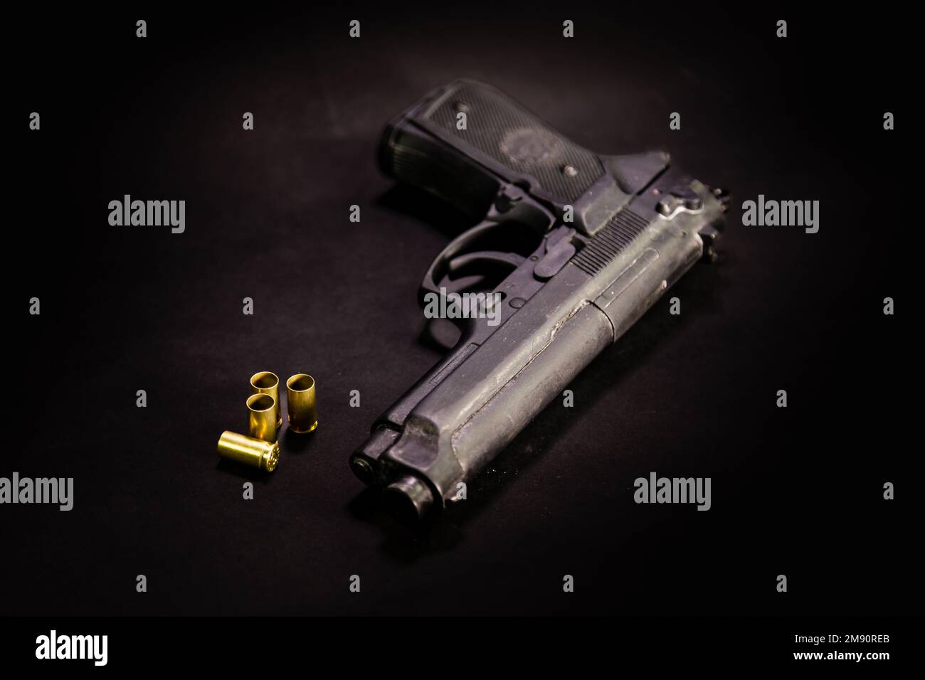 Pistol with 9mm shell casings on black background, macro shot Stock ...