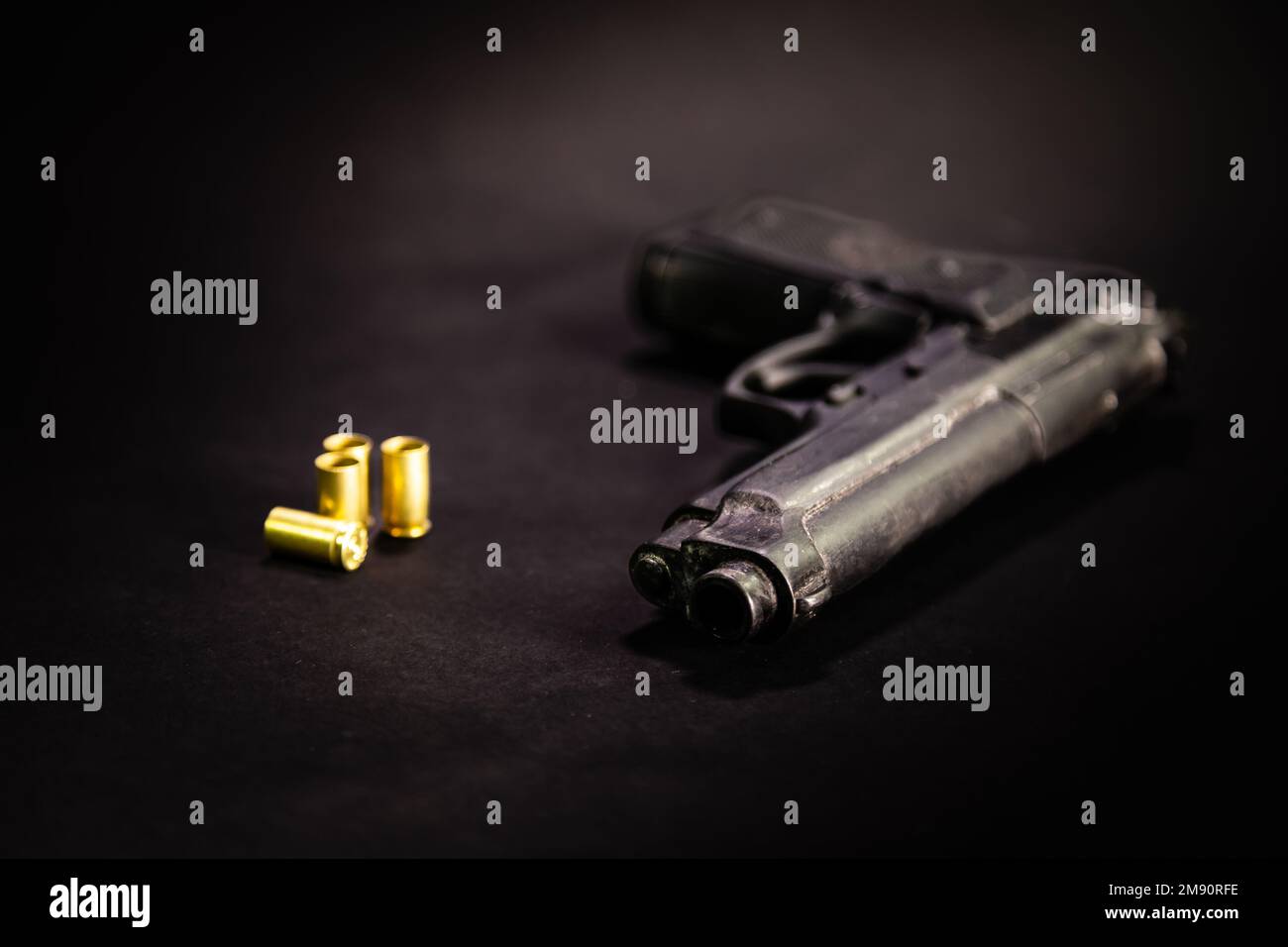 Pistol with 9mm shell casings on black background, macro shot Stock ...