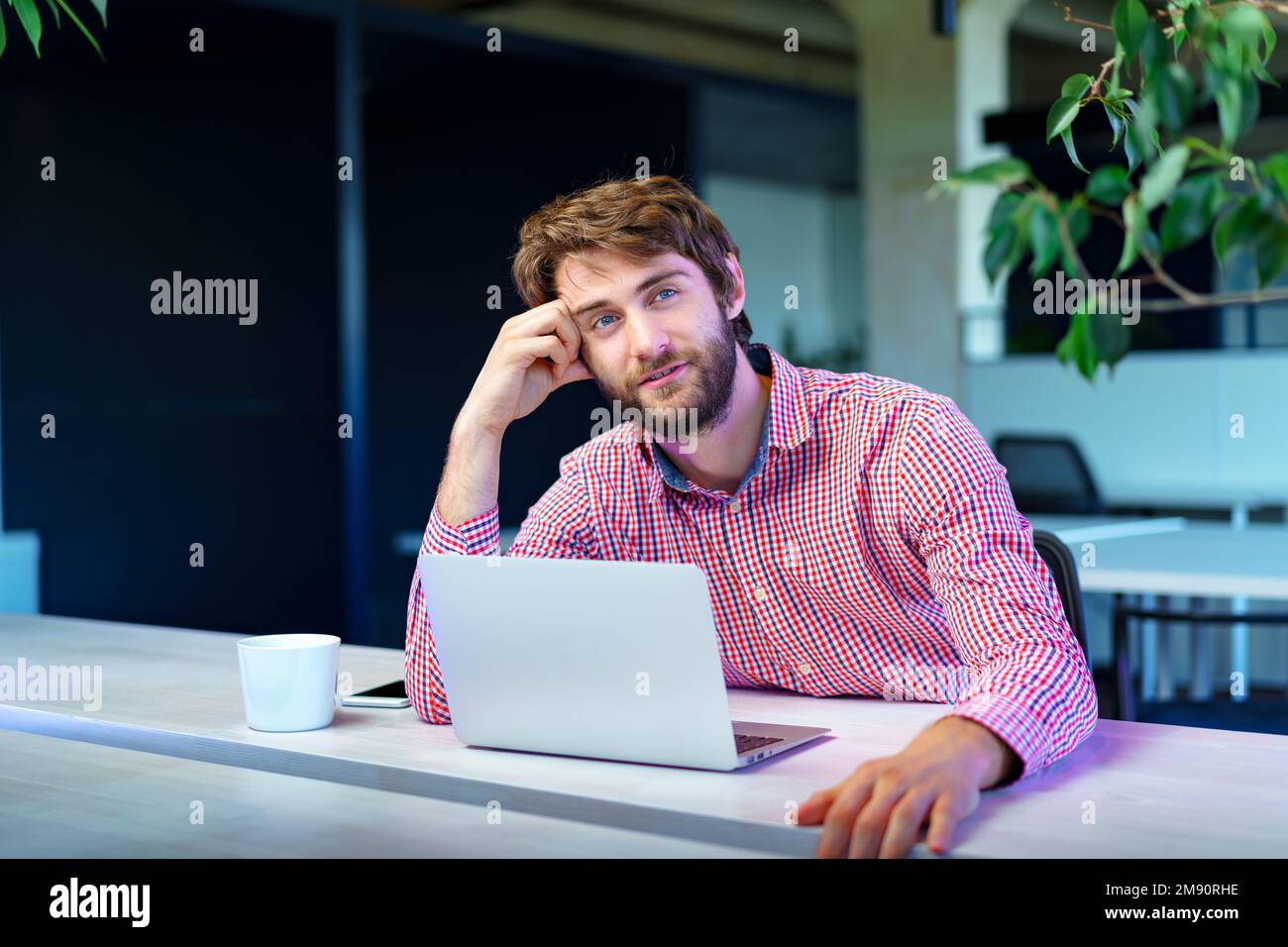 Tired businessman working on his computer in open space office Stock ...
