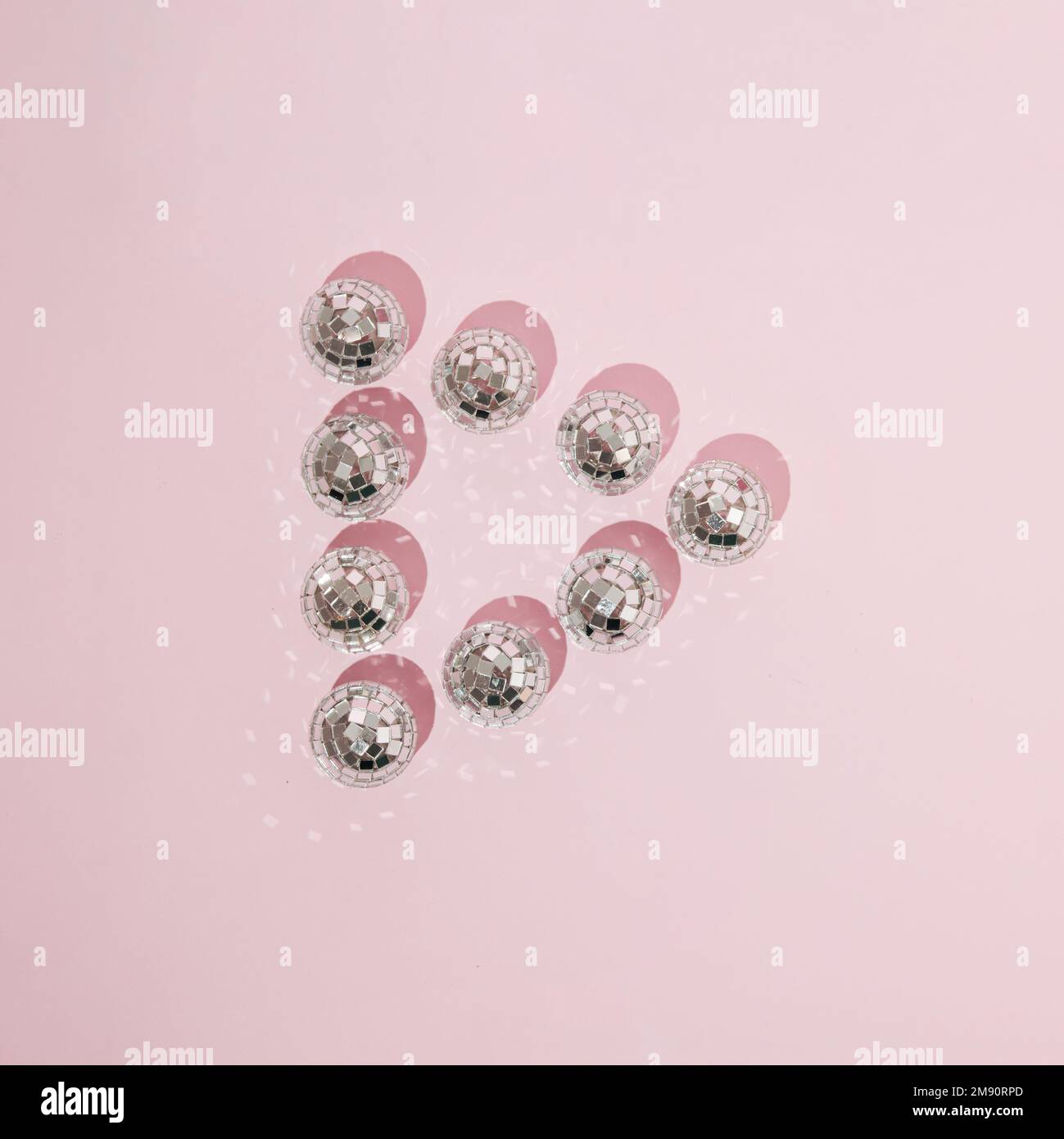 Play button sign made with shiny disco balls on pastel pink background ...