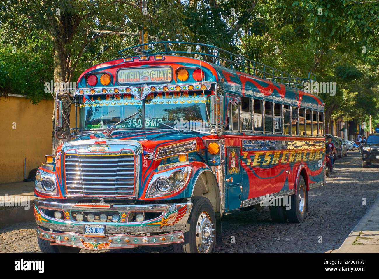 Colorful chicken bus running on the main street of Antigua Guatemala ...