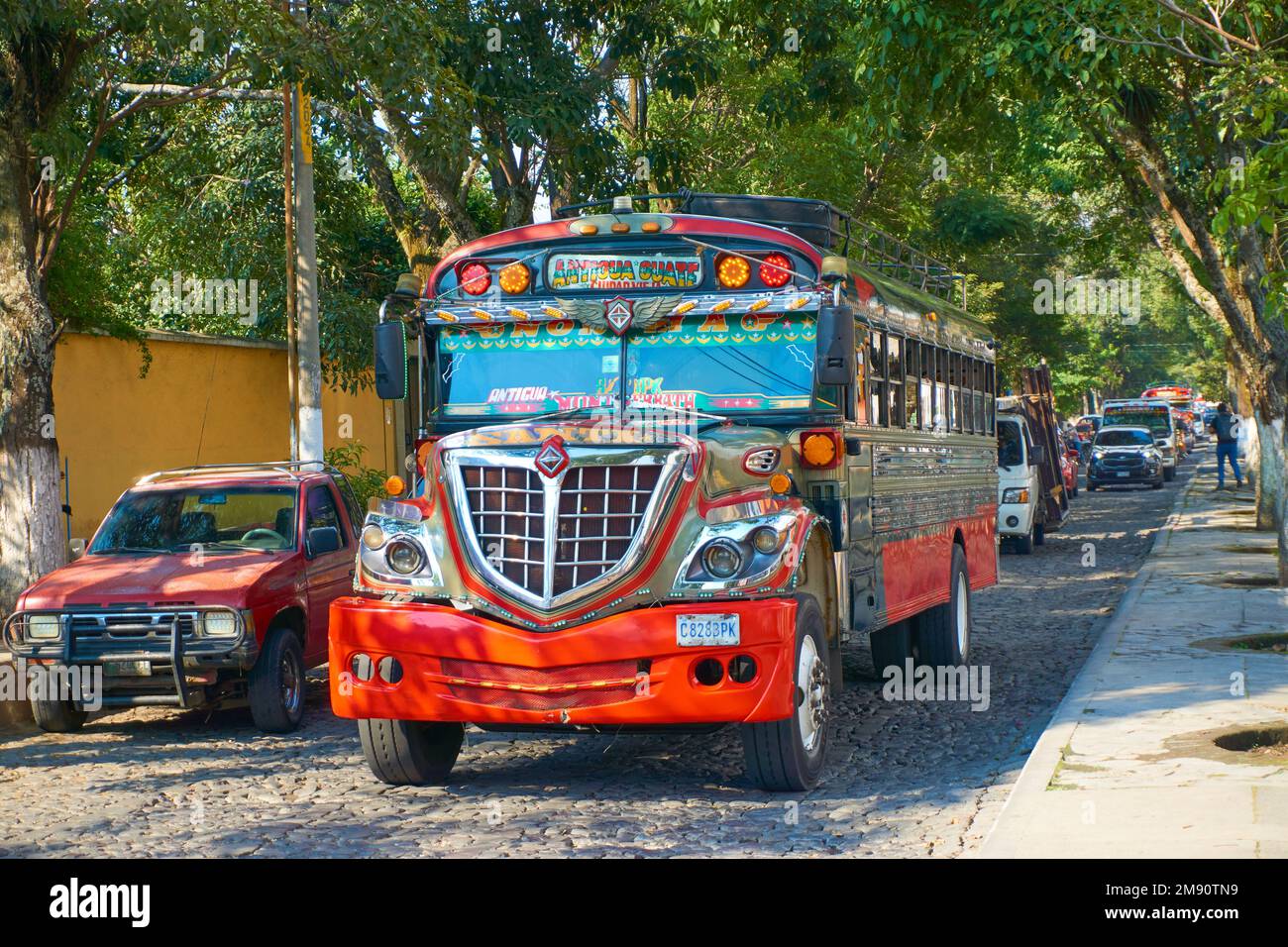 Colorful chicken bus running on the main street of Antigua Guatemala ...