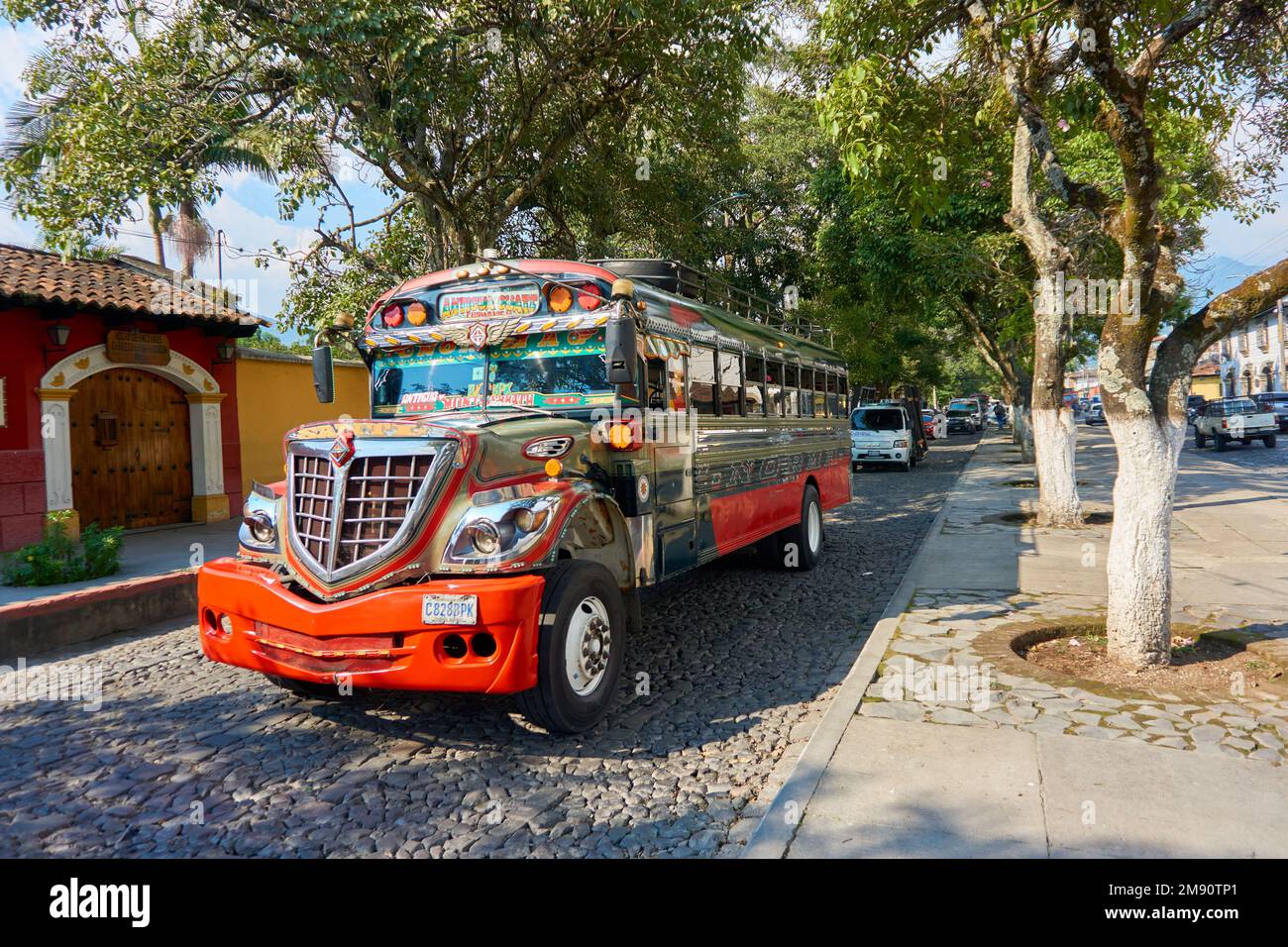 Colorful chicken bus running on the main street of Antigua Guatemala ...