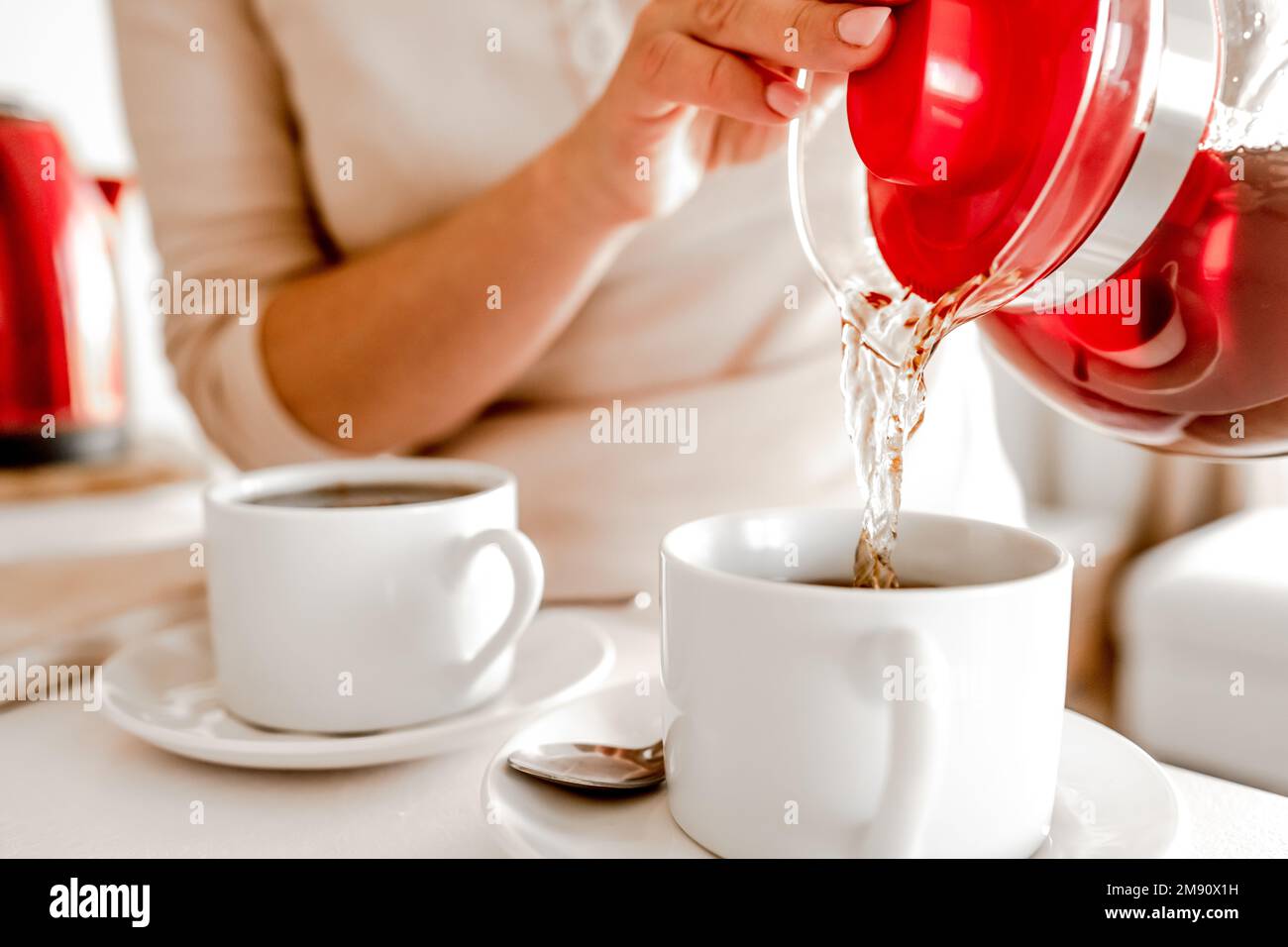 Tea preparation with teapot and cups at kitchen Stock Photo - Alamy