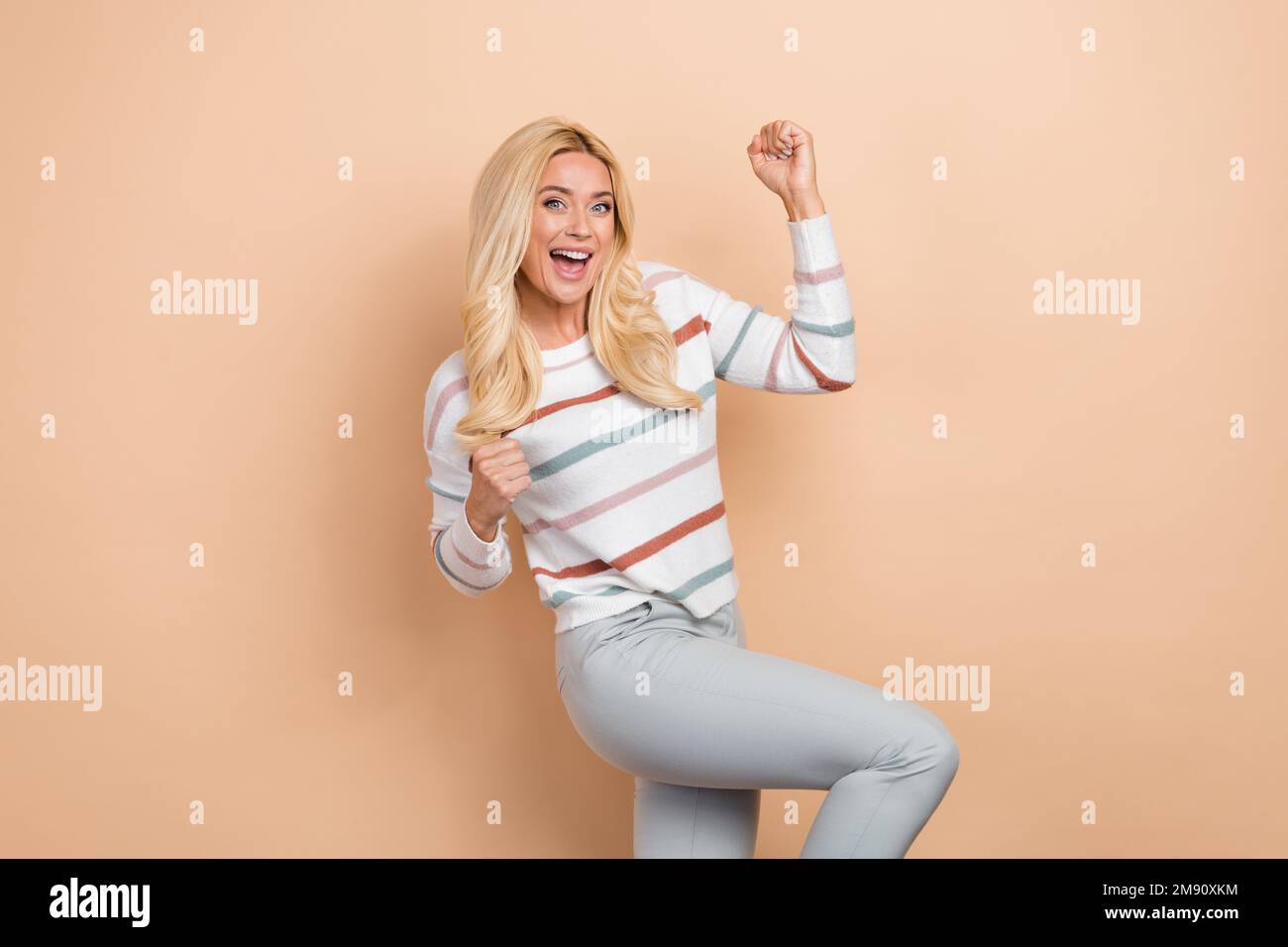Photo of good mood ecstatic woman with curly hairstyle dressed striped ...