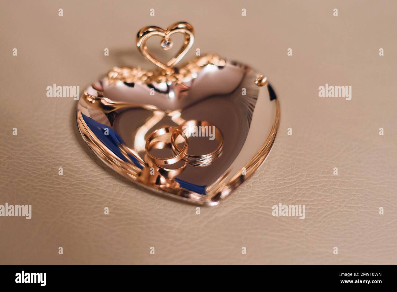 gold traditional wedding rings on a beautiful stand with reflection ...