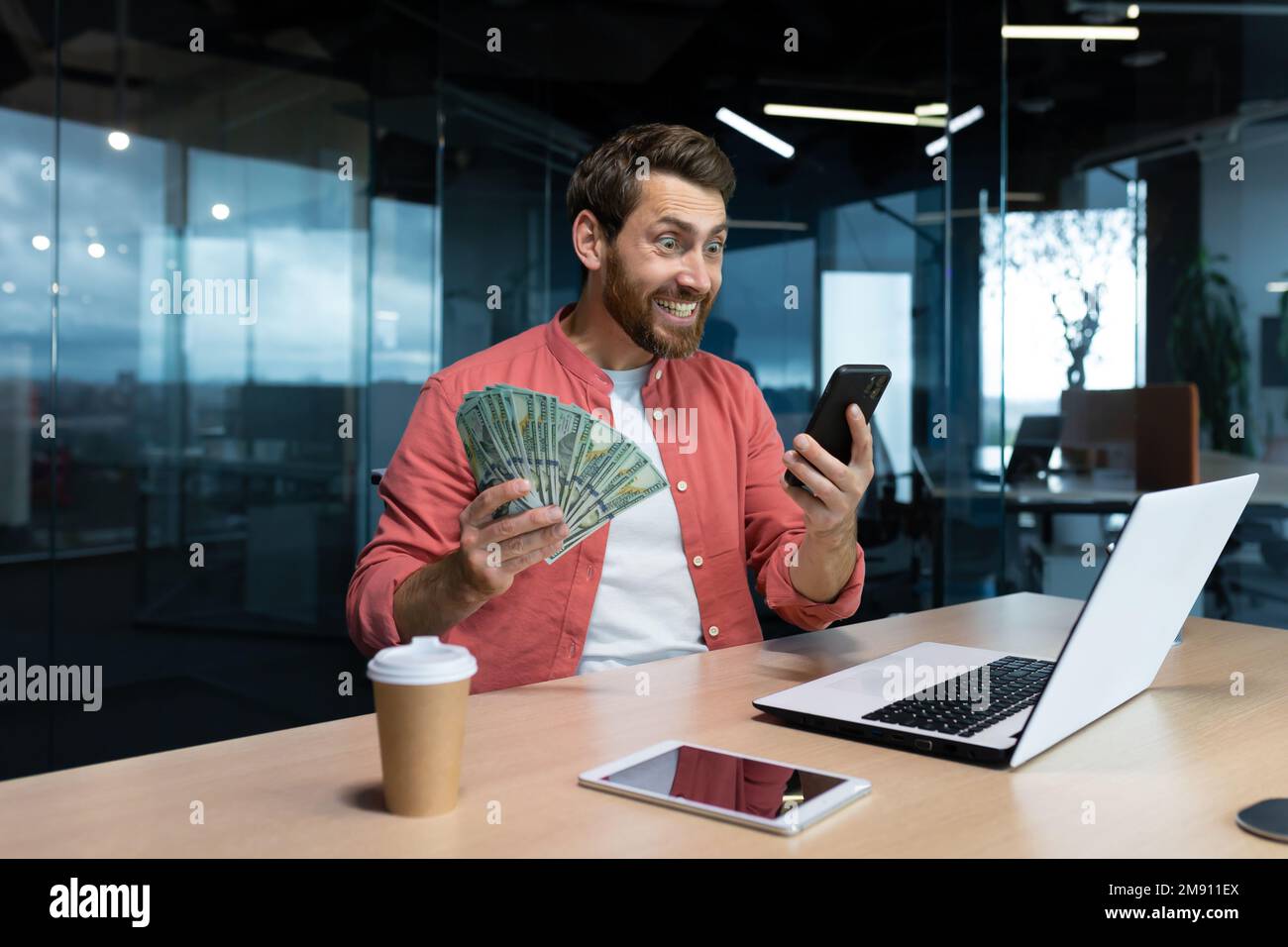 Successful businessman in red shirt celebrating victory and good ...