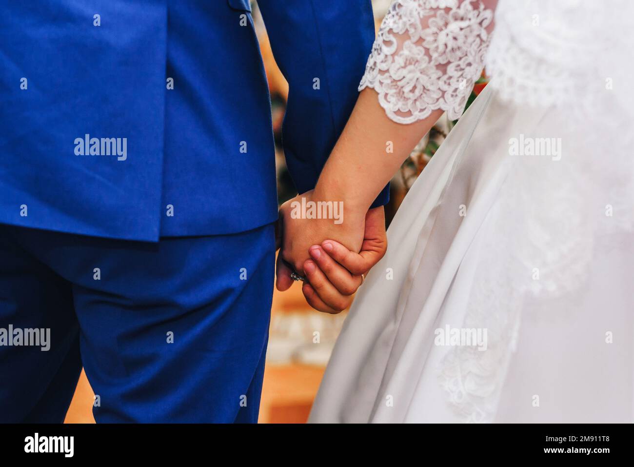 newlyweds in love bride and groom holding hands together at the wedding ...