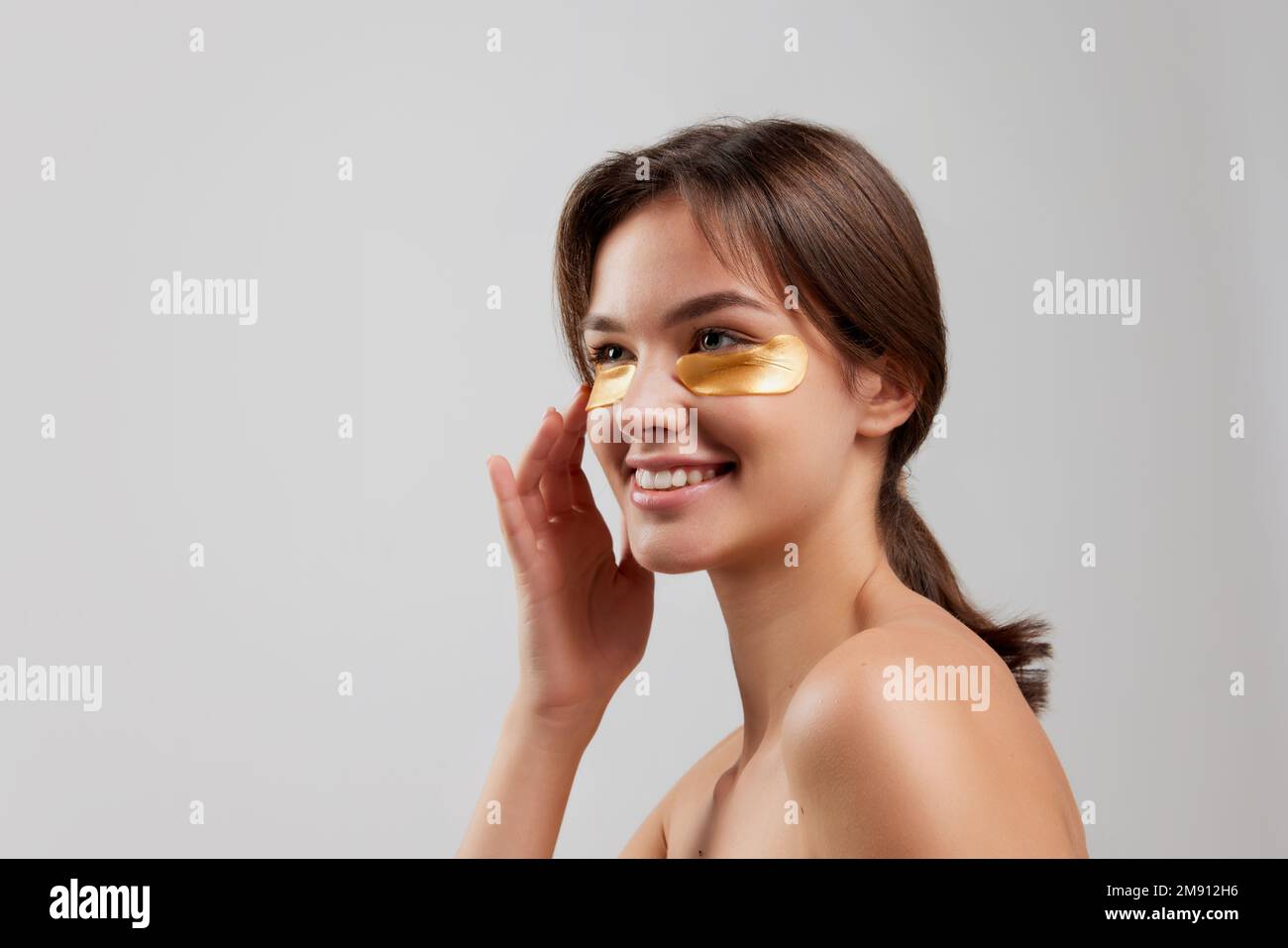 Emotional young beautiful girl with well-kept skin doing face ...