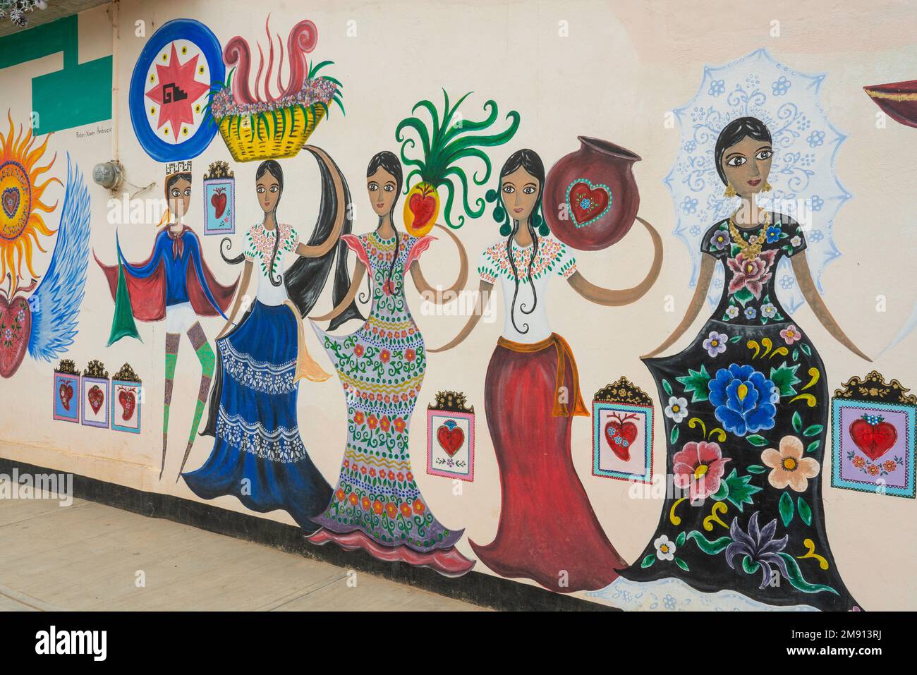 A mural of women in traditional dance costumes on a wall in the town of ...