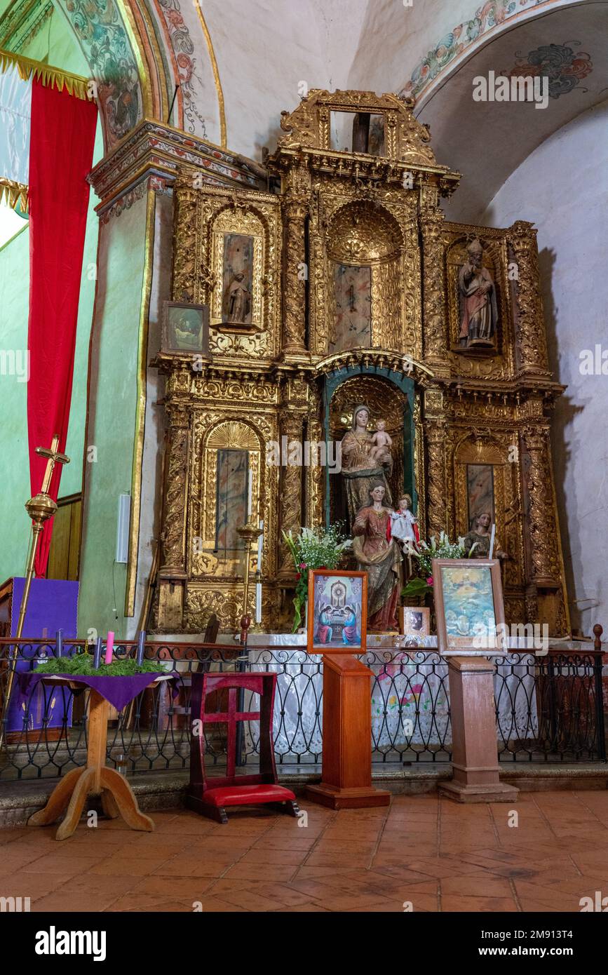 An altarpiece or retablo in the nave of the Catholic parish church of ...