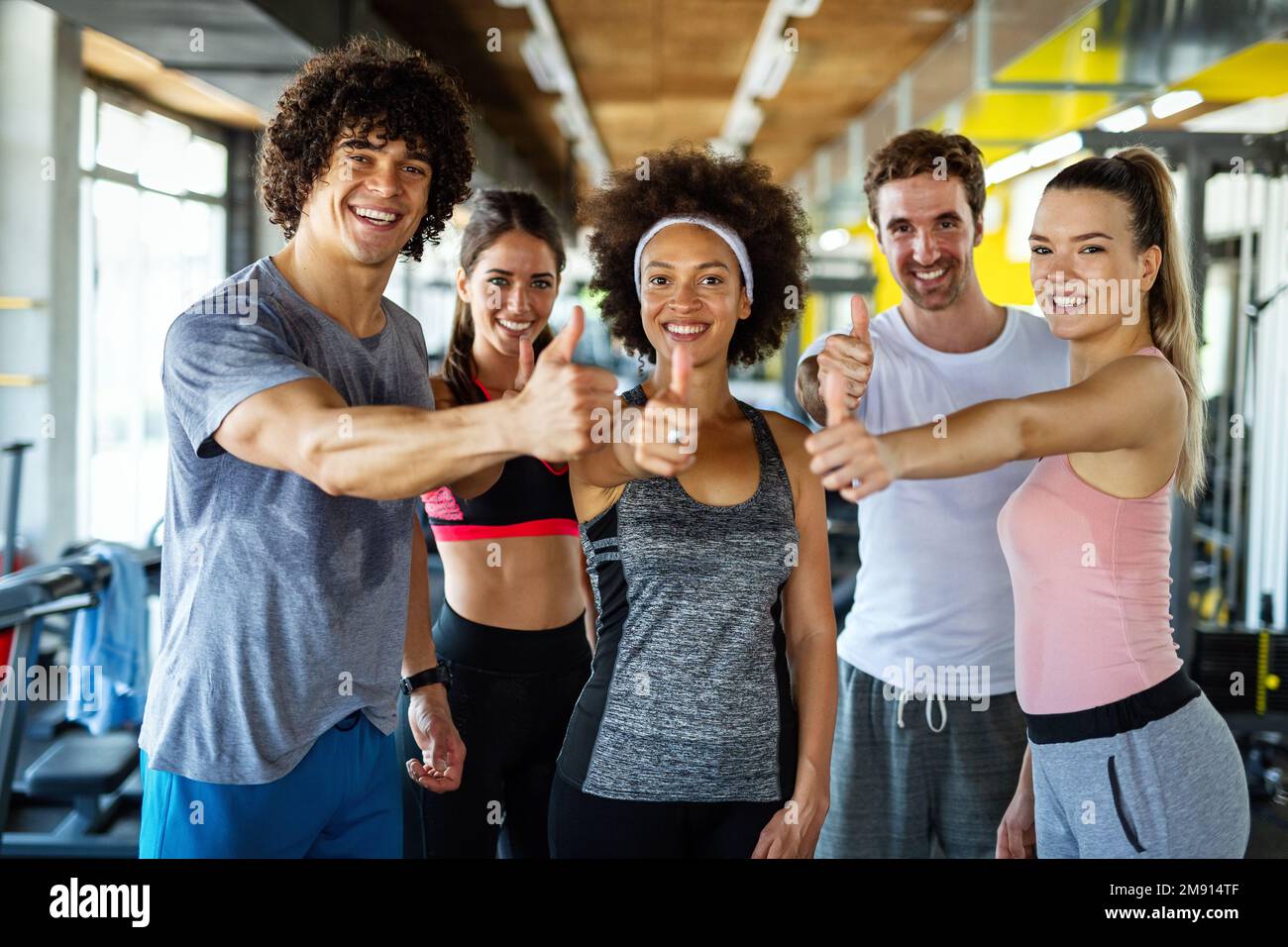 Group of fit people working out in a gym. Multiracial friends ...
