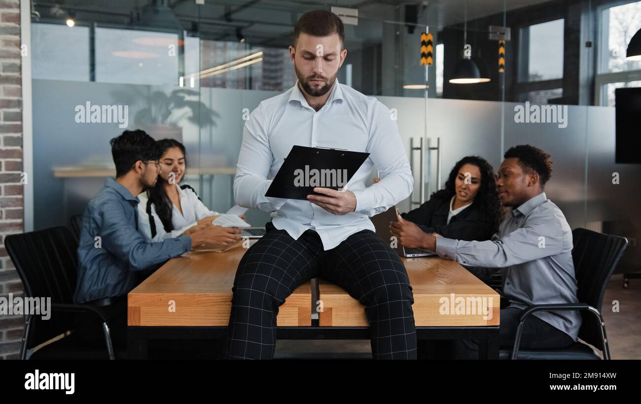 Serious businessman boss leader man sit on desk table in office check ...