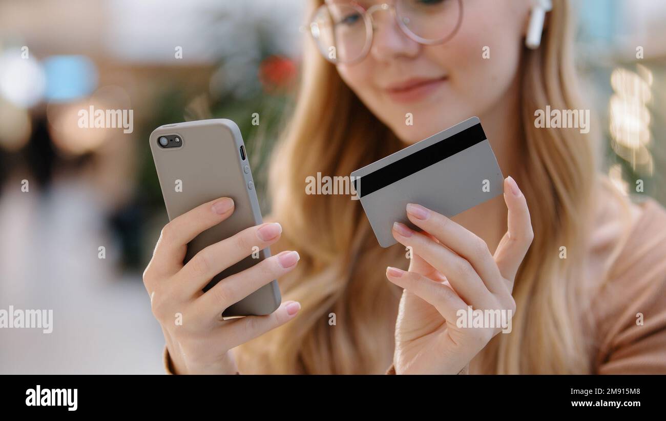 Close-up young girl hands holding smartphone and credit card happy ...