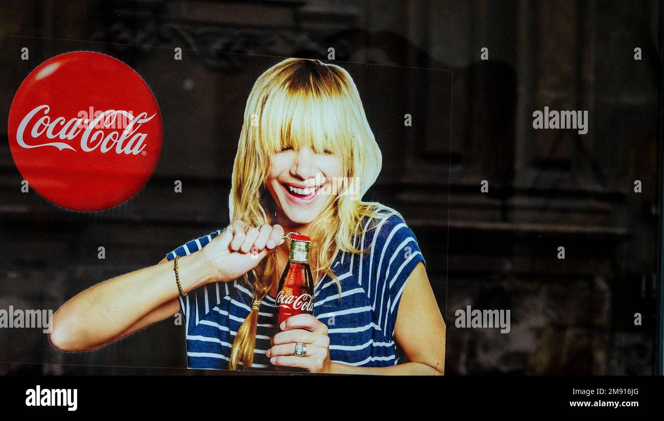 A girl opening a bottle of Coca Cola on an advertisement Stock Photo ...