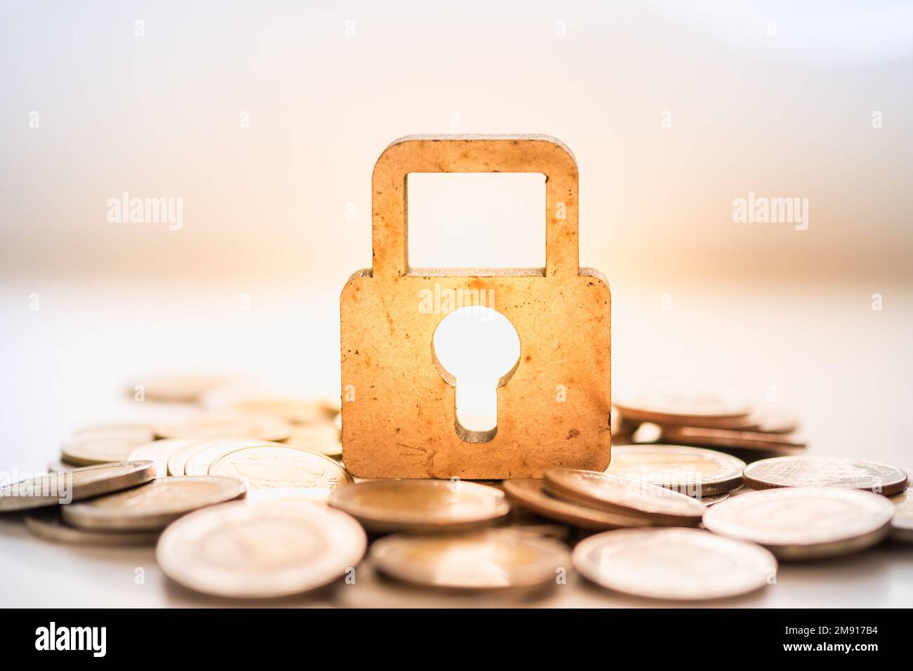 Money and Security Concept. Wooden master key lock icon on pile of ...