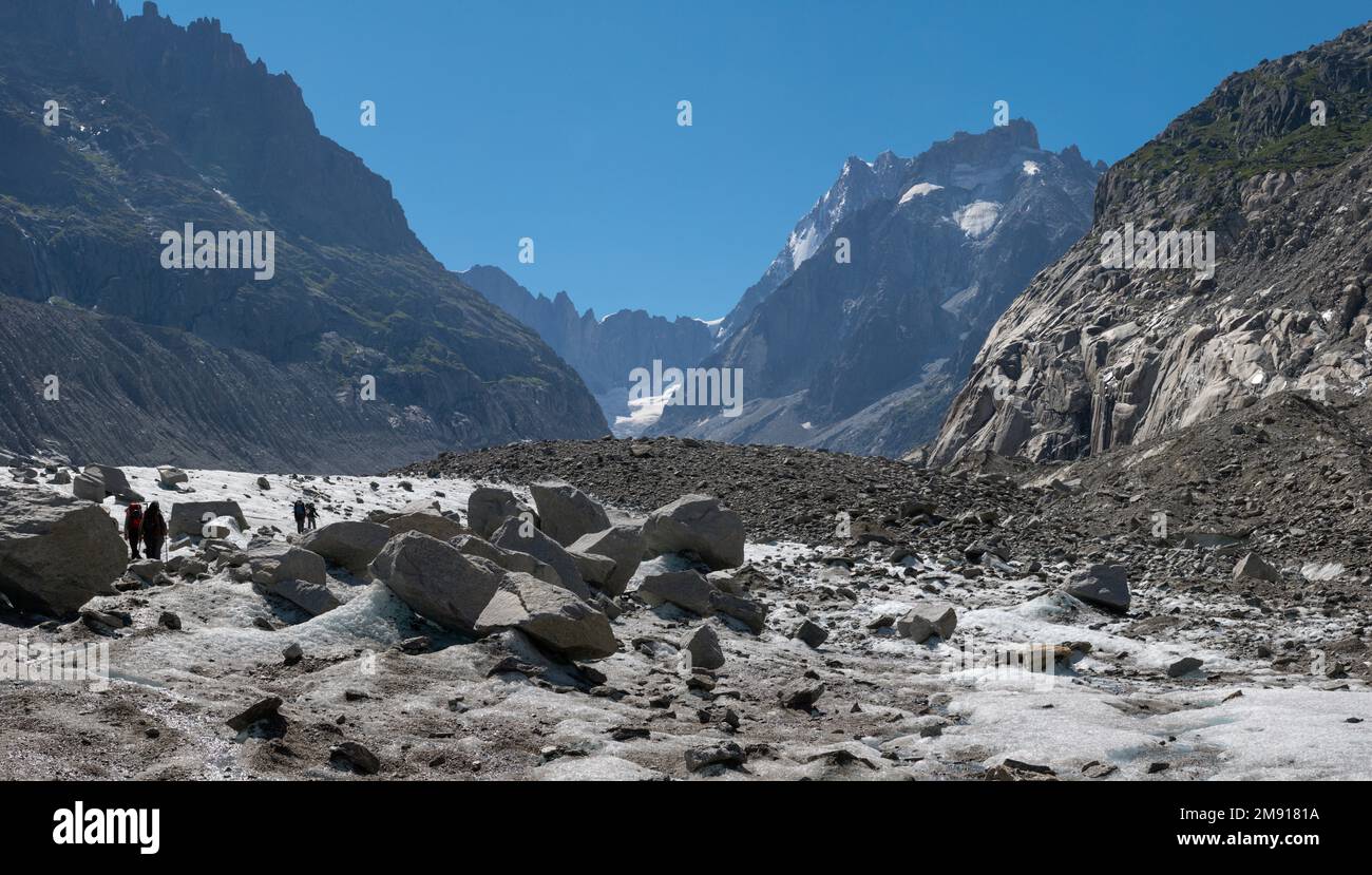 The glacial stream on the glacier Mer de Glace with the Garand Jorasses ...