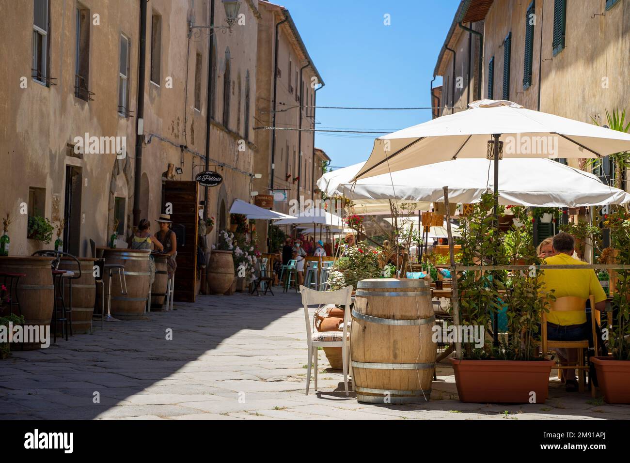 People dining on the street in an old town in Tuscany, Italy Stock ...