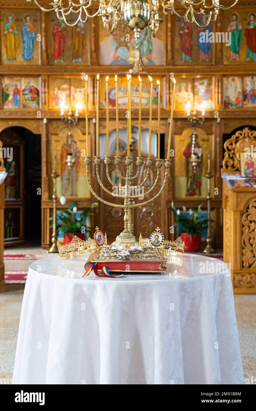 A vertical shot of a golden candle holder with two crowns inside an ...