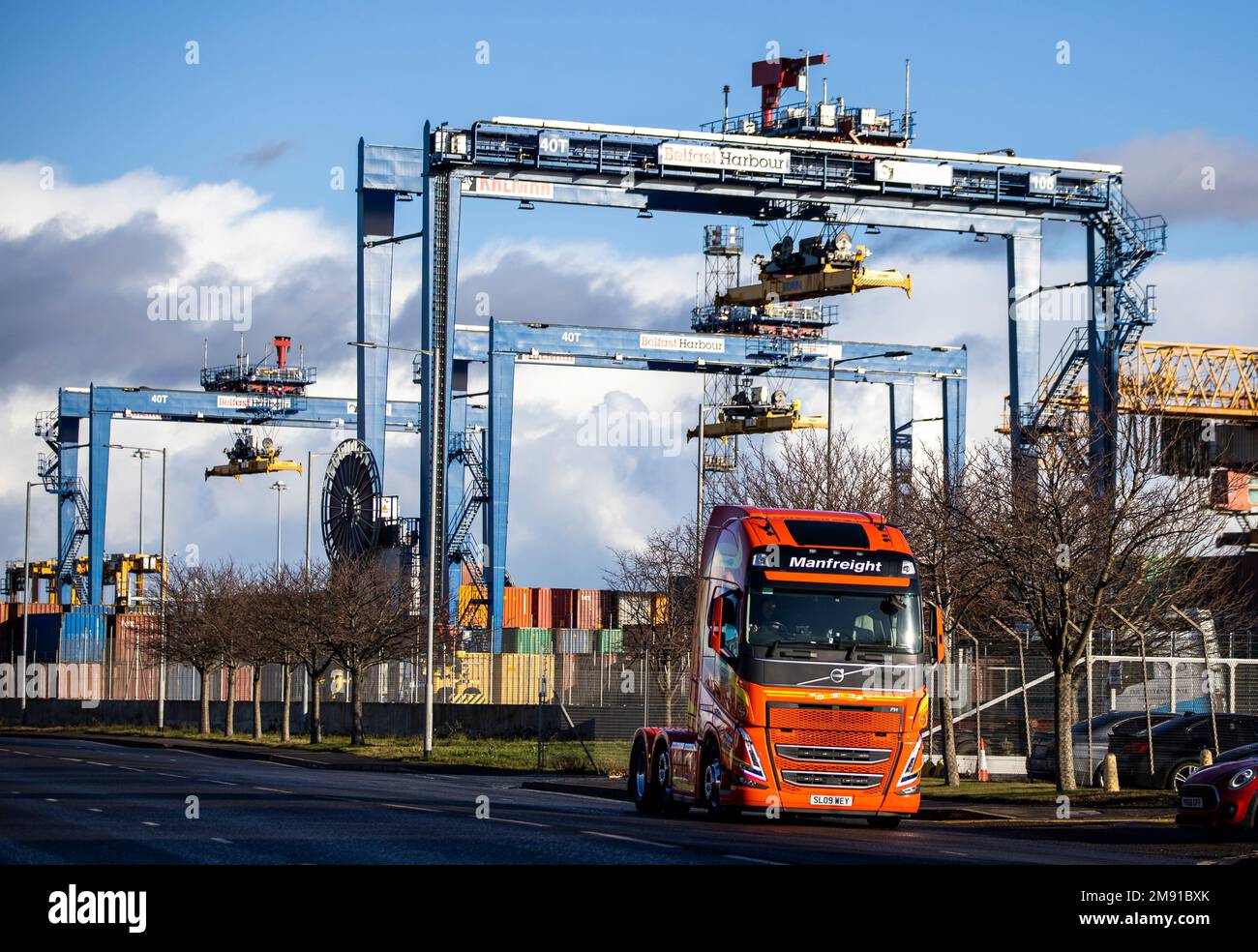 An HGV lorry drives passed the container cranes of Belfast Harbour at ...