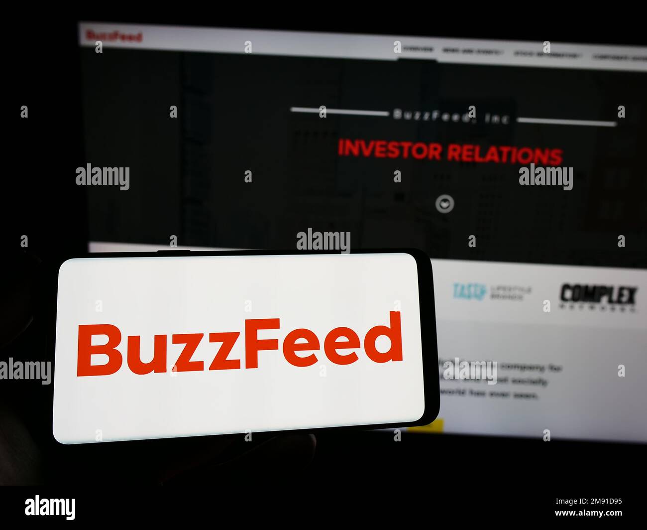 Person holding mobile phone with logo of American Internet media ...