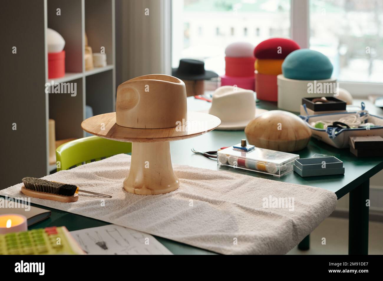 Workplace of modern fashion designer and owner of small craftshop selling handmade hats and ...
