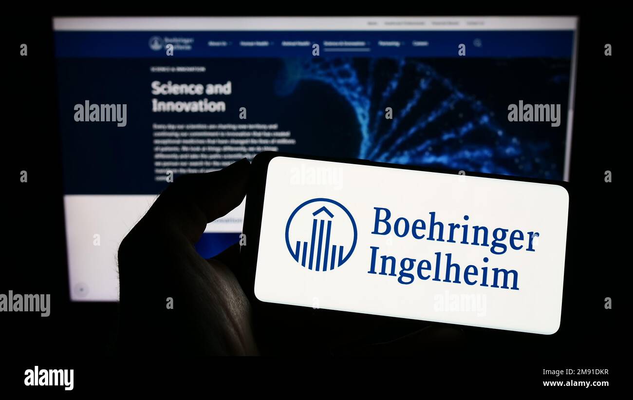 Person holding cellphone with logo of pharmaceutical company Boehringer ...