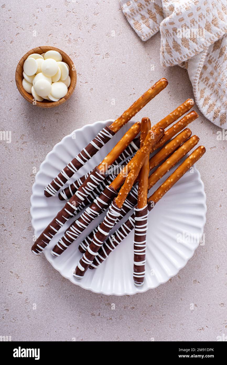 Chocolate covered pretzel rods homemade on a white plate Stock Photo ...