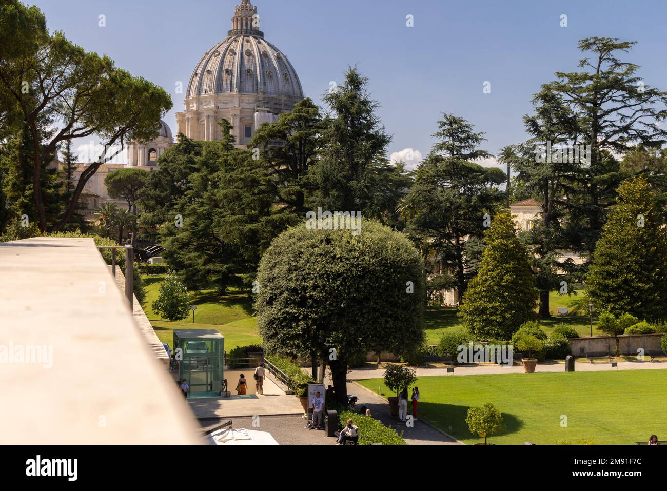 Inner courtyard of Vatican city museum with visitors and St. Peters ...