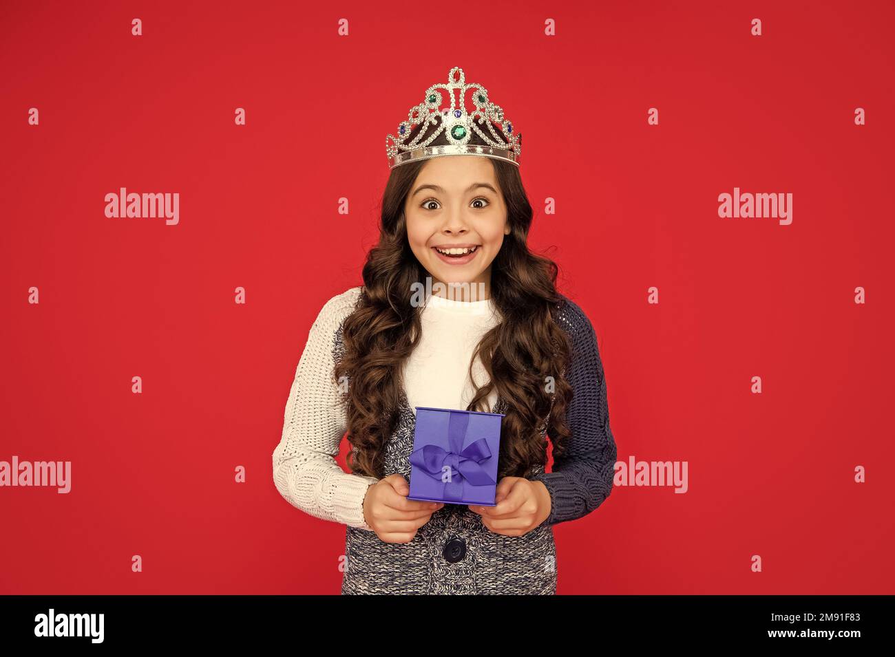 amazed child in queen crown. princess in tiara hold box. kid with ...