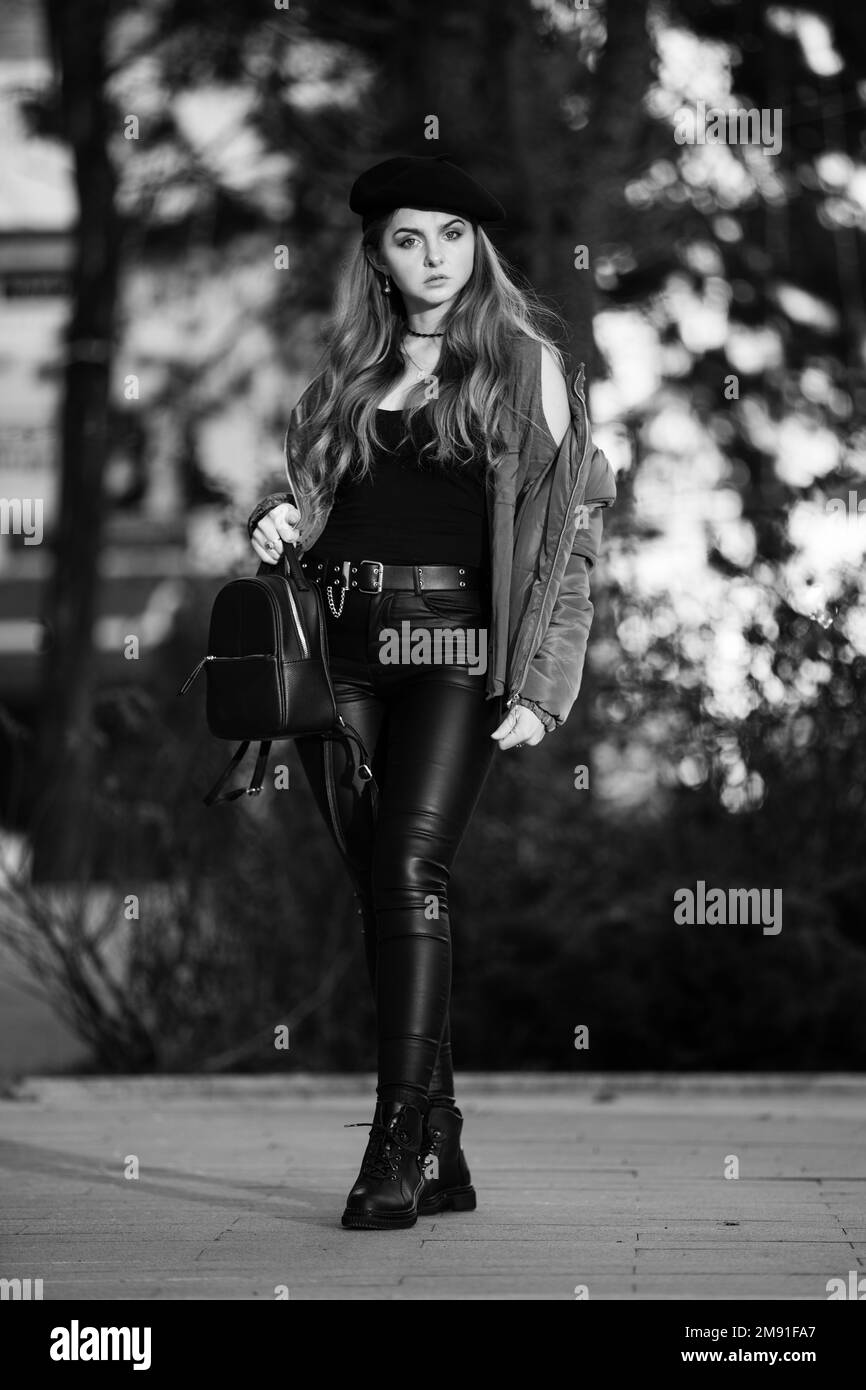 A vertical grayscale shot of a Caucasian woman wearing a casual outfit ...
