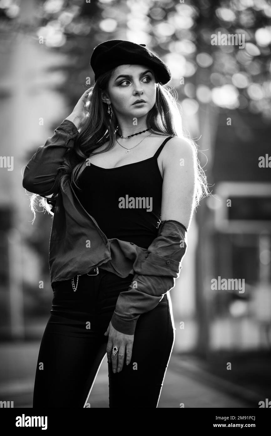 A vertical grayscale shot of a Caucasian woman wearing a casual outfit ...