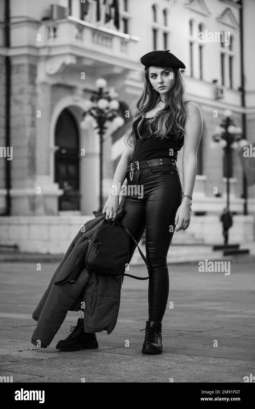 A vertical grayscale shot of a Caucasian woman wearing a casual outfit ...