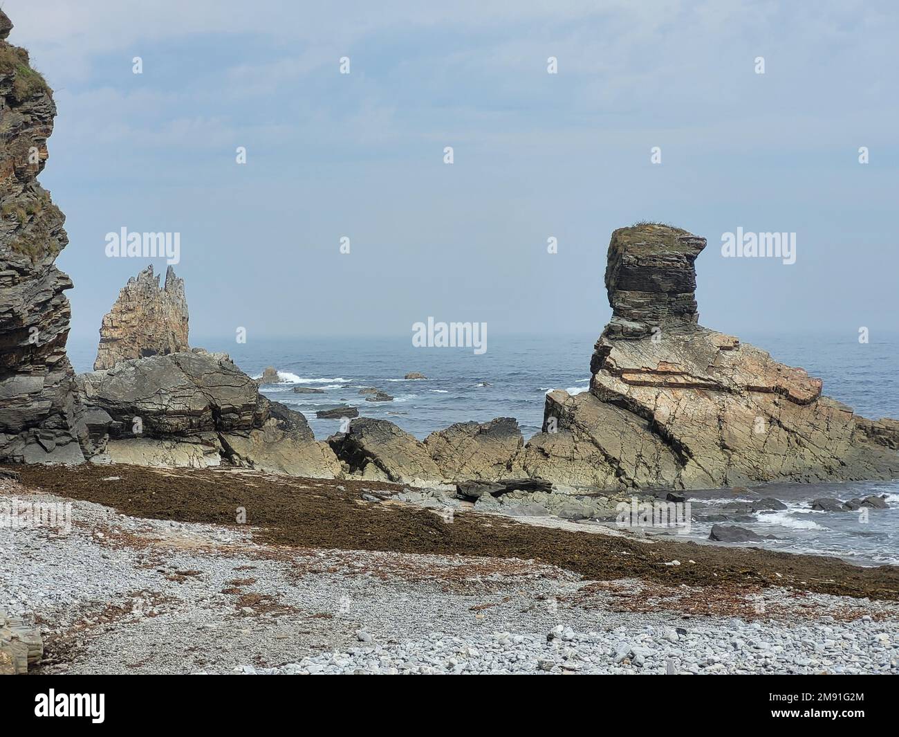 A scenic view of rock formations on Playa de Portizuelo beach on blue ...