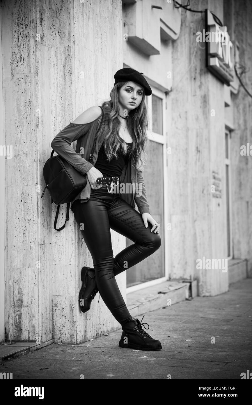 A vertical grayscale shot of a Caucasian woman wearing a casual outfit ...