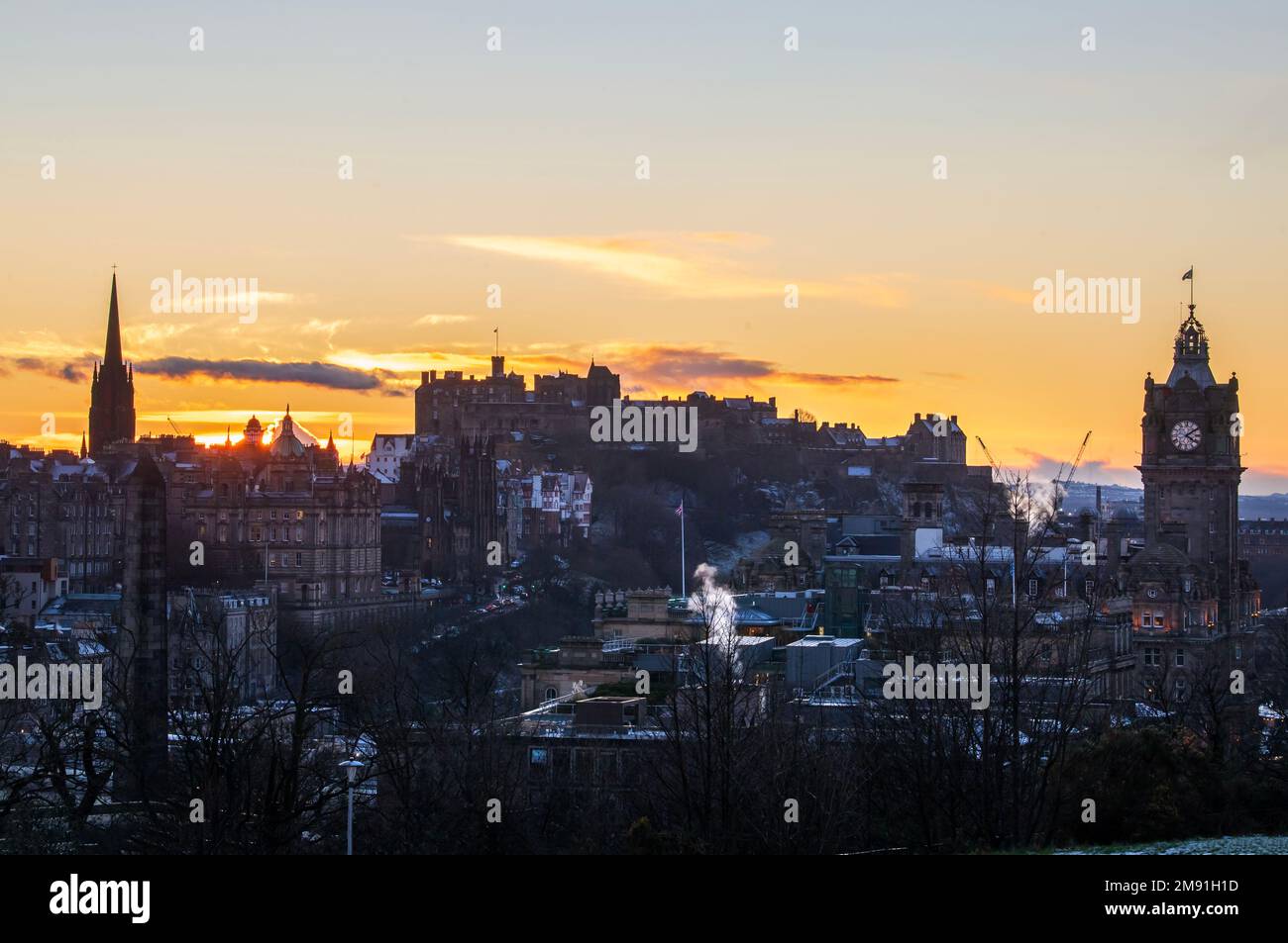 The low winter sun sets behind Edinburgh Castle. Picture date: Monday ...